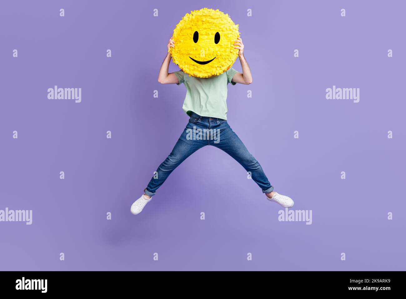 Full length photo of nice young man jumping hide face smile emoticon ...