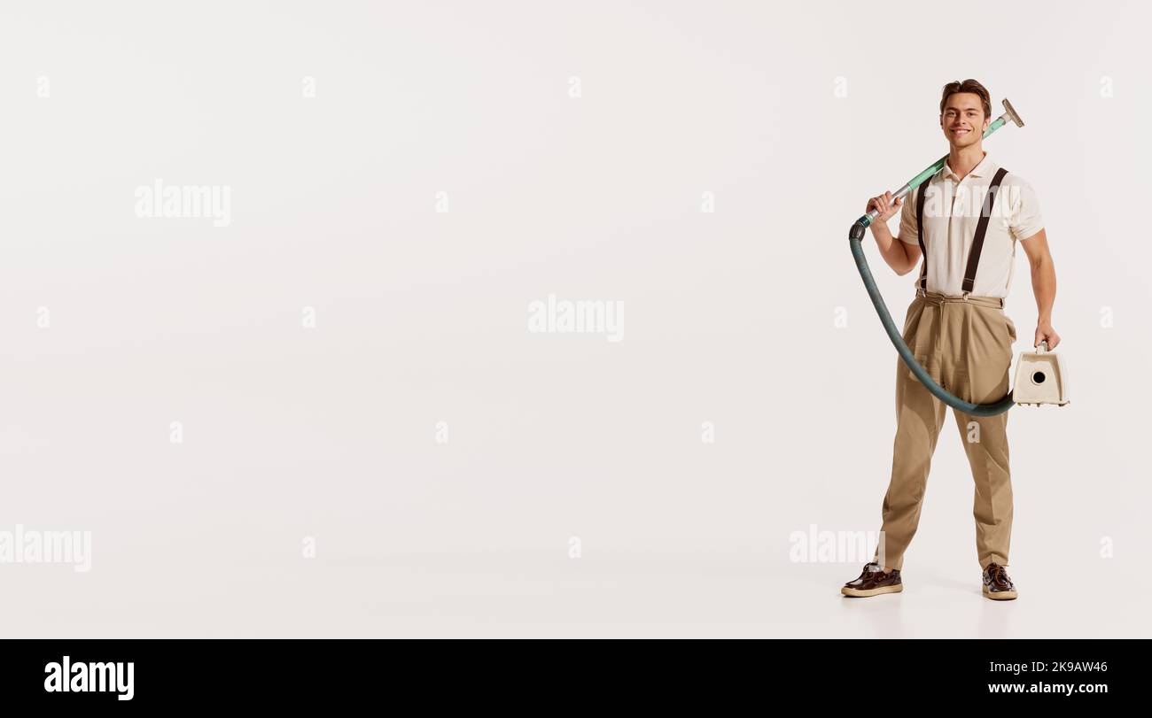 Portrait of handsome stylish young man posing with vintage vacuum ...