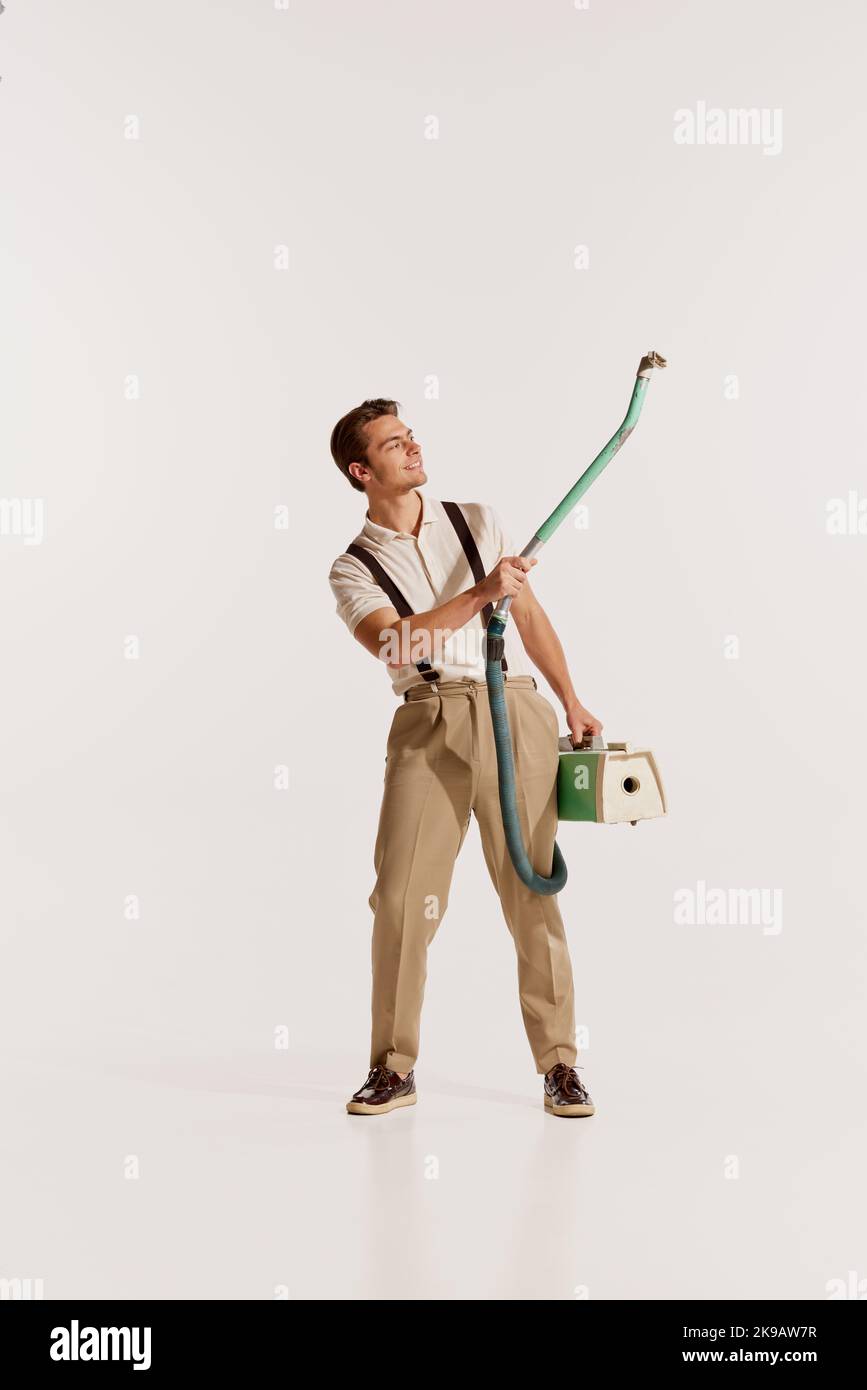 Portrait of handsome stylish young man posing with vintage vacuum ... Portrait of handsome stylish young man posing with vintage vacuum ...