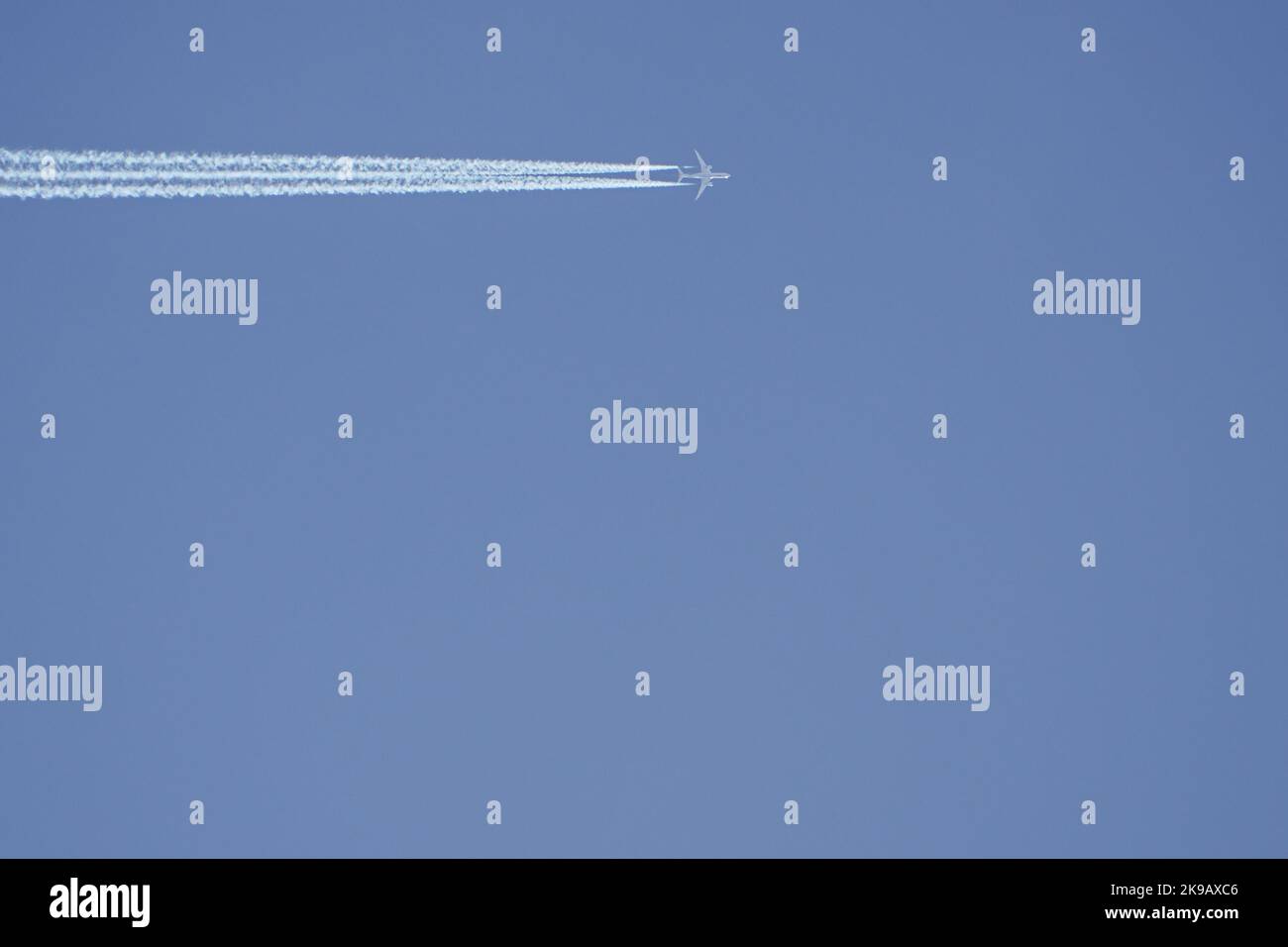 plane with white trail in clear sky. From the left. aviation in the sky ...