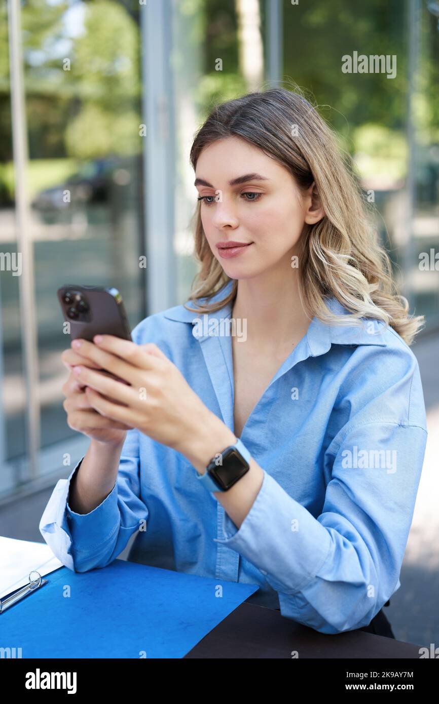 Vertical shot of successful businesswoman sitting outdoors in park ...