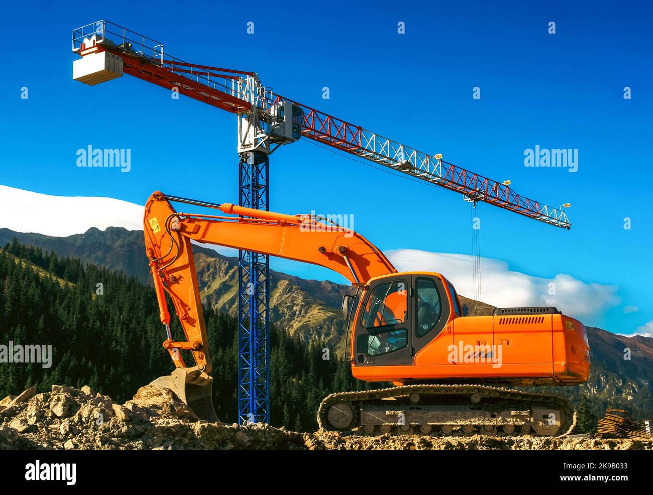Excavator and crane on construction site in forest and nature ...