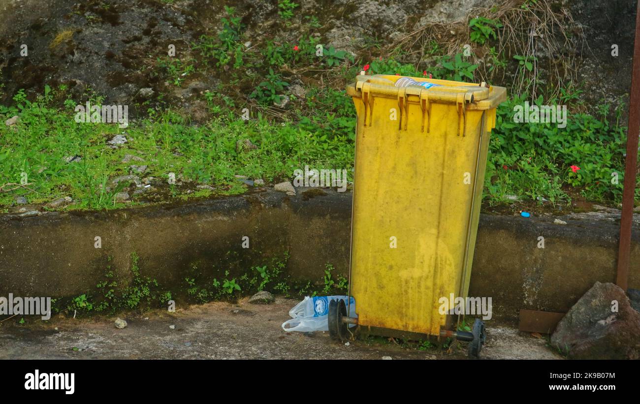 yellow trash can at a tourist spot Stock Photo - Alamy