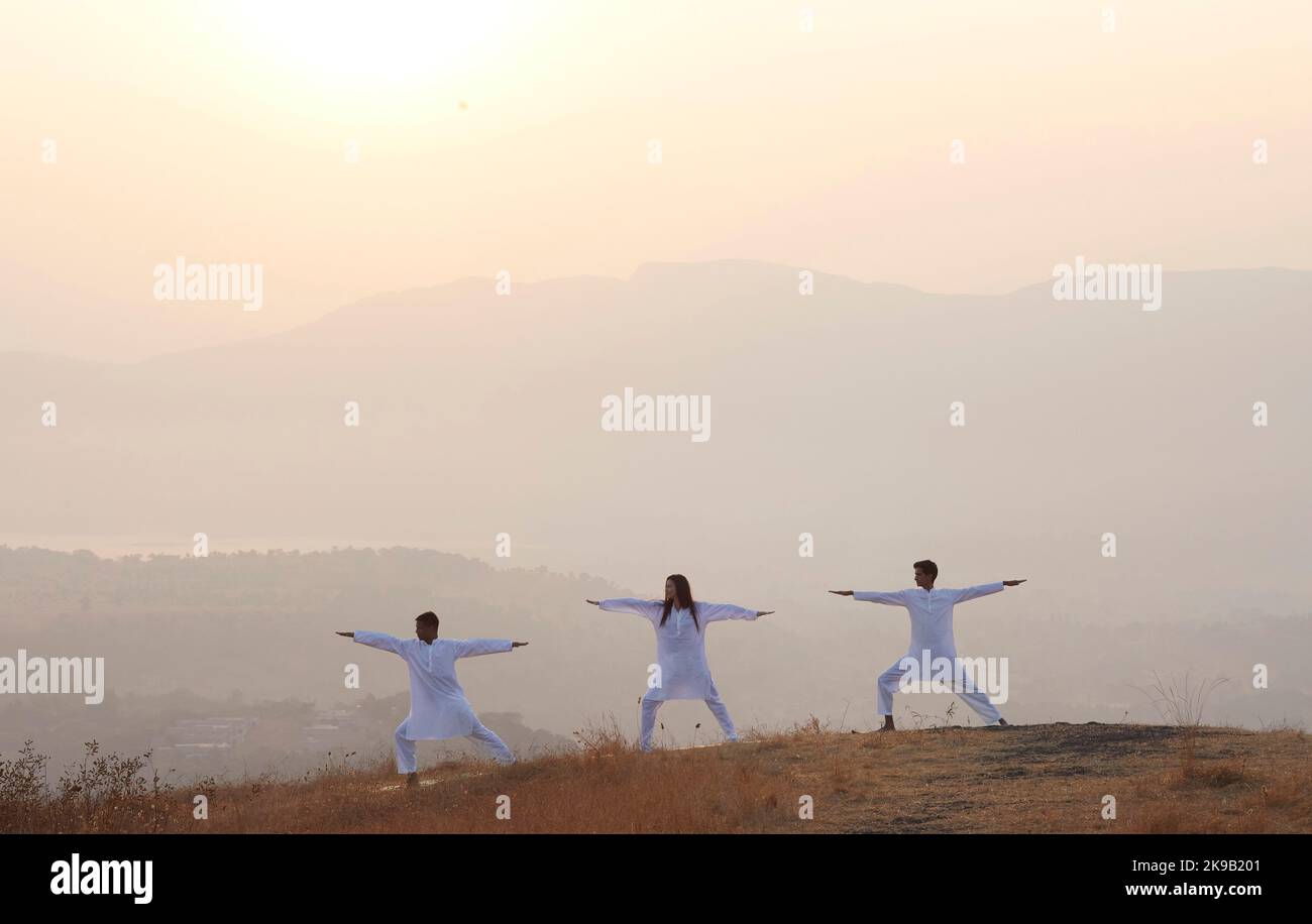 Yoga on Shillim peak at dawn with Tung fort in background. Indian ...