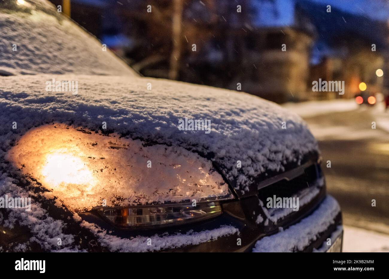 Parked car with light on covered by snow at night Stock Photo - Alamy