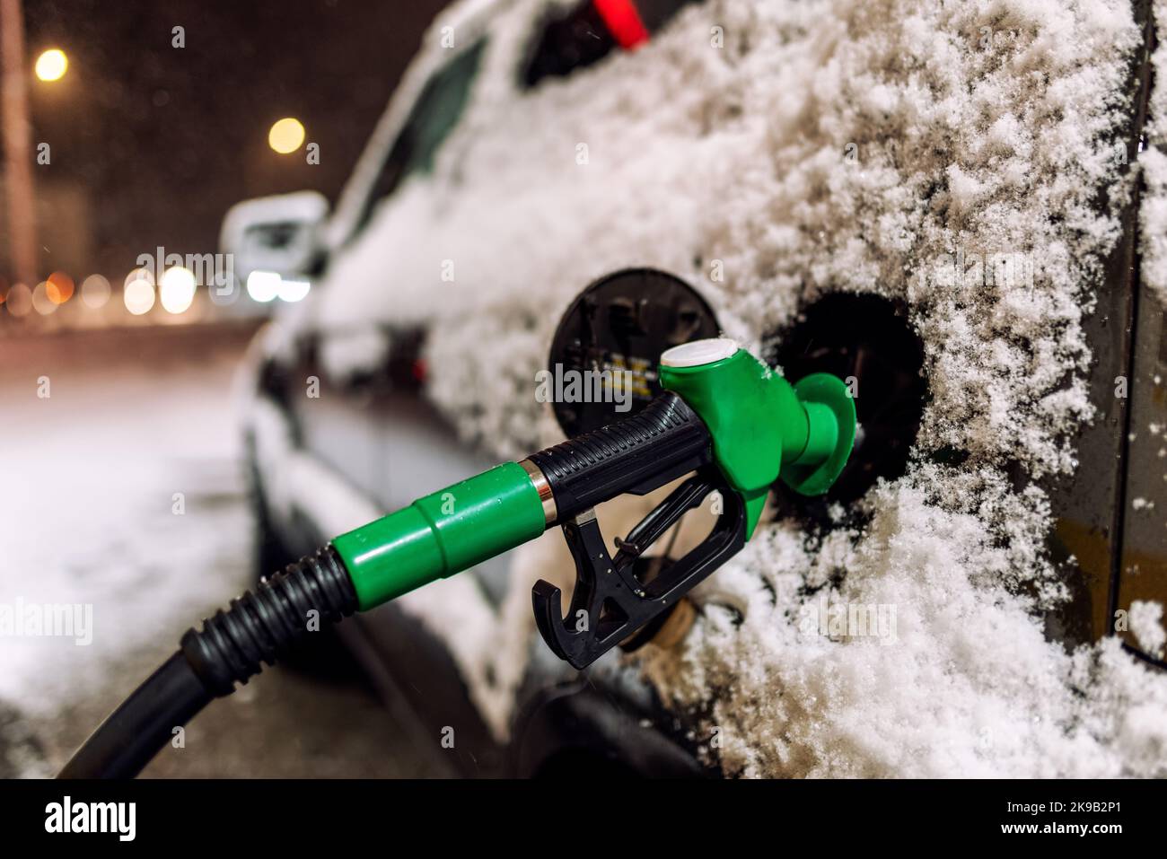 Snow covered car refueling at the gas station at night Stock Photo - Alamy