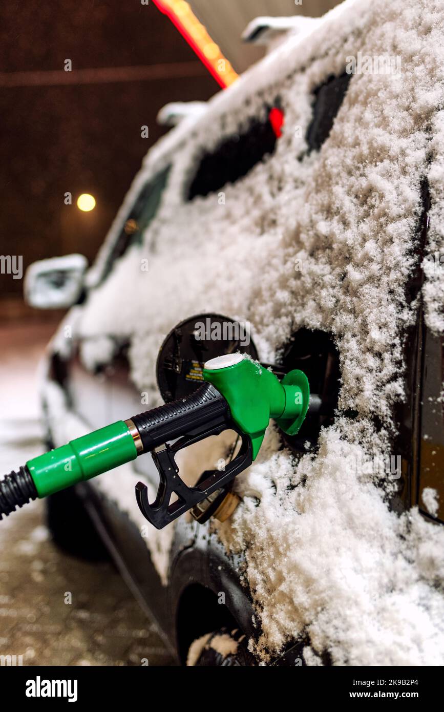 Snow covered car refueling at the gas station at night Stock Photo - Alamy