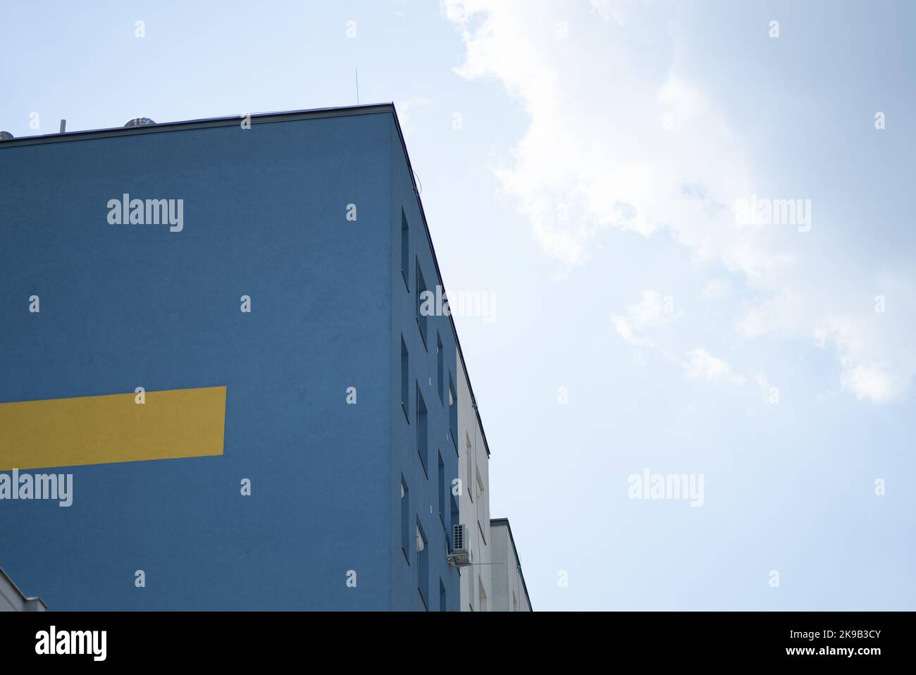 Blue and yellow side of a tall block of flats Stock Photo - Alamy