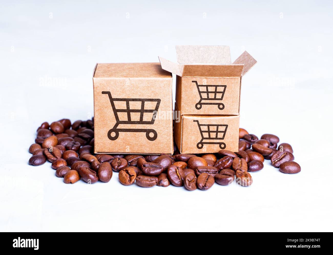 Pile of roasted coffee beans and miniature cardboard boxes with ...