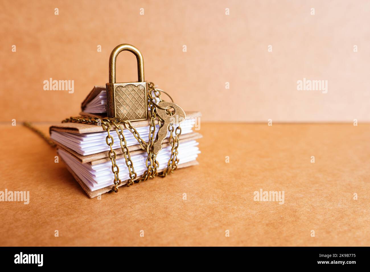 Stack of tiny books wrapped with chain and secured with a keyed padlock ...