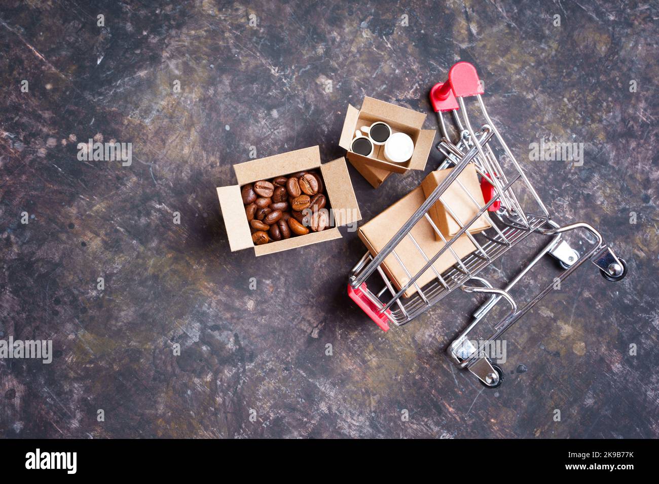 Overturned miniature push trolley with tiny shipping boxes with roasted ...