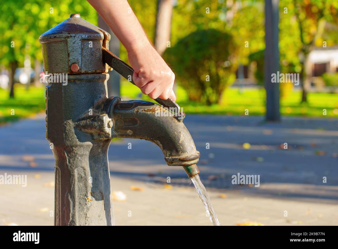 Hand pressing the lever of the public drinking water pump Stock Photo ...
