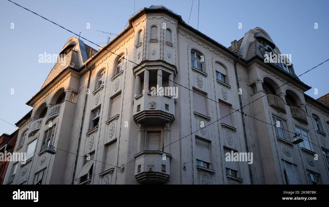Tall building at the corner of a street with wires crossing each other ...