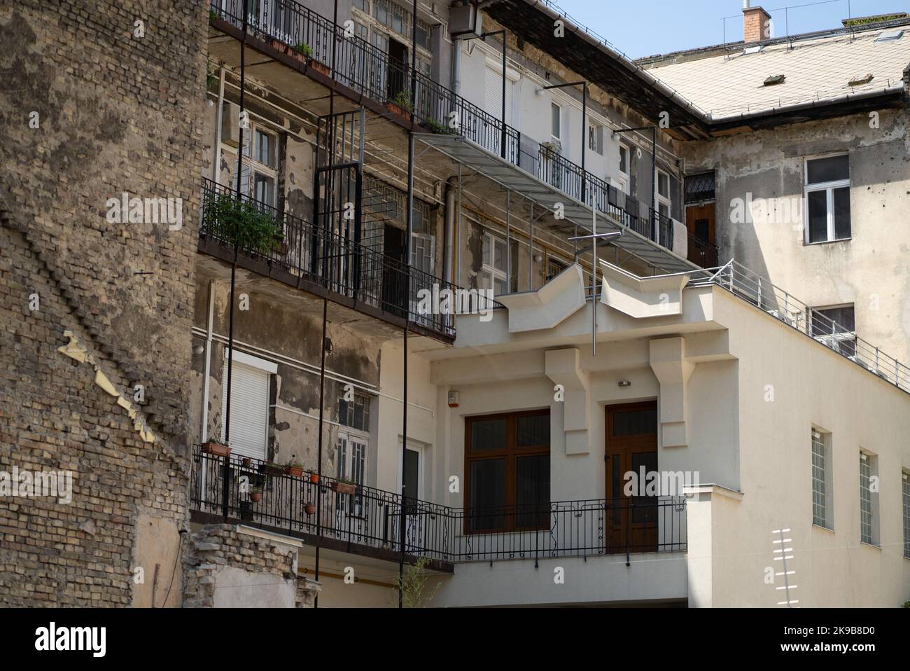Backyard of an old poor worn building with flats and their balconies ...