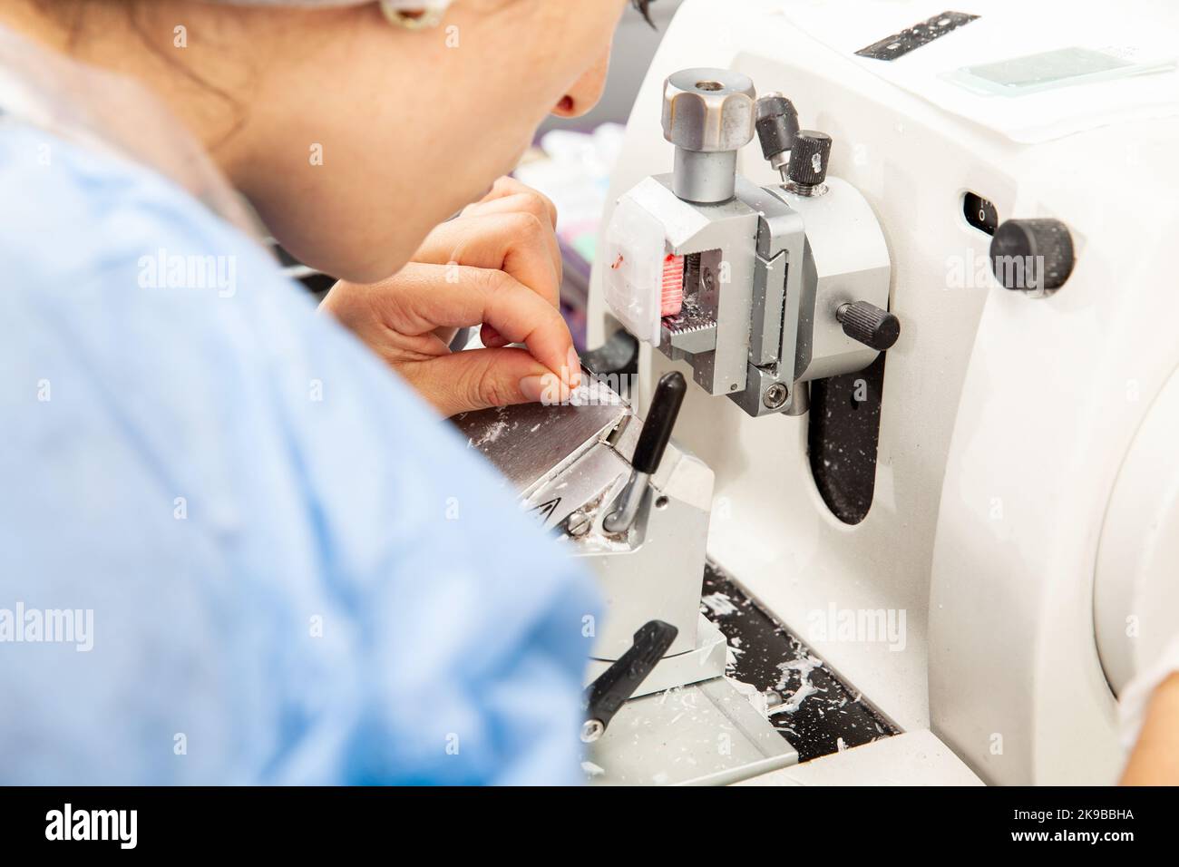 Closeup to the scientist hands working on a rotary microtome to obtain ...