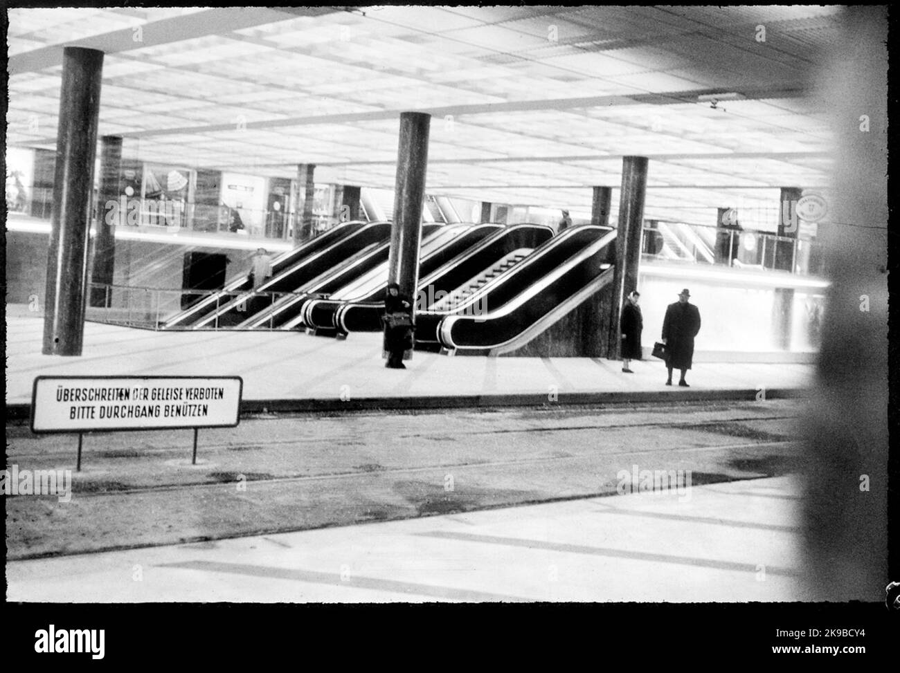 Tram track with warning sign. In the rear escalator to the commuter ...