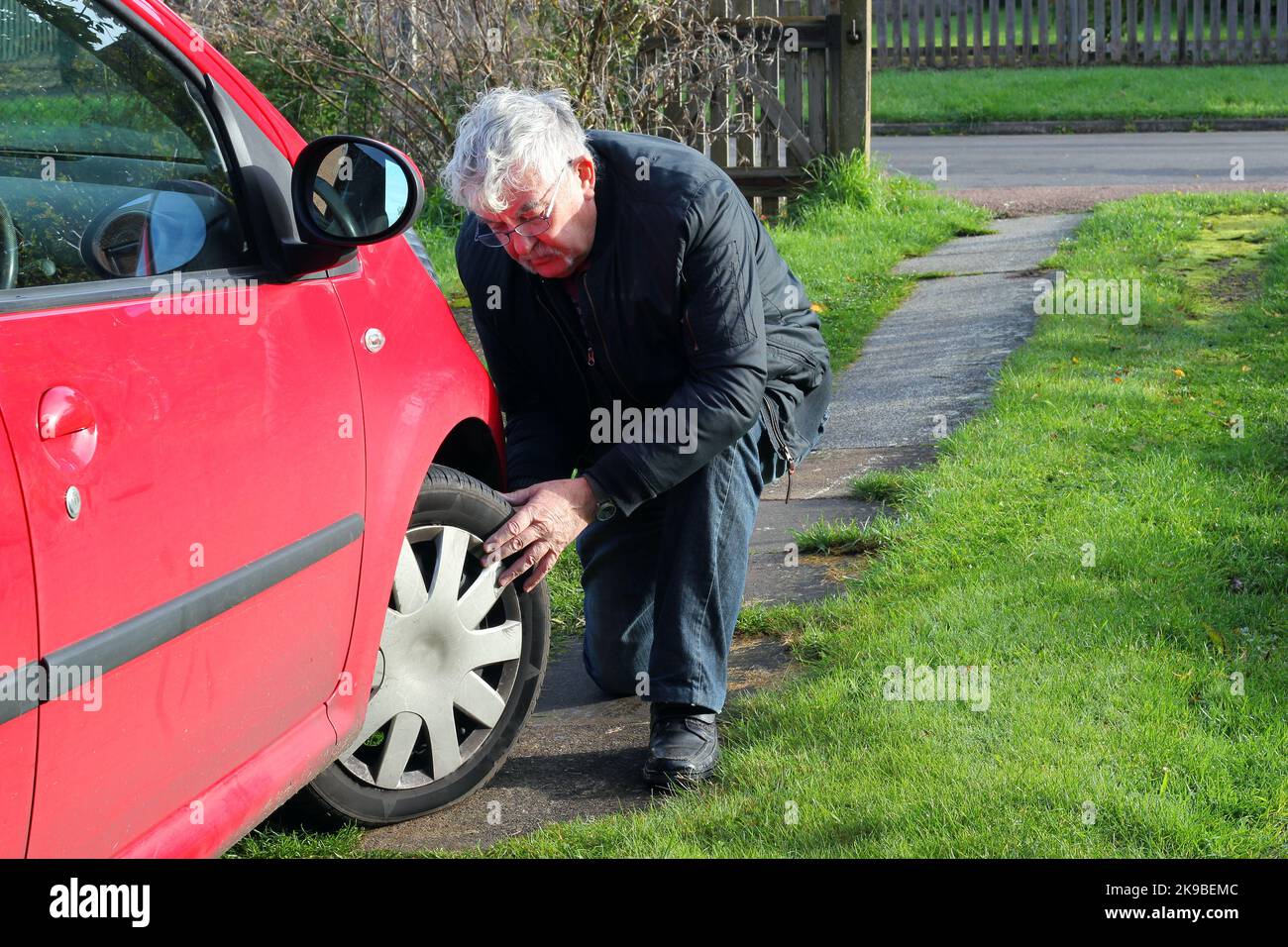 checking tyre tread on a motor vehicle. Man checking depth of his tires ...