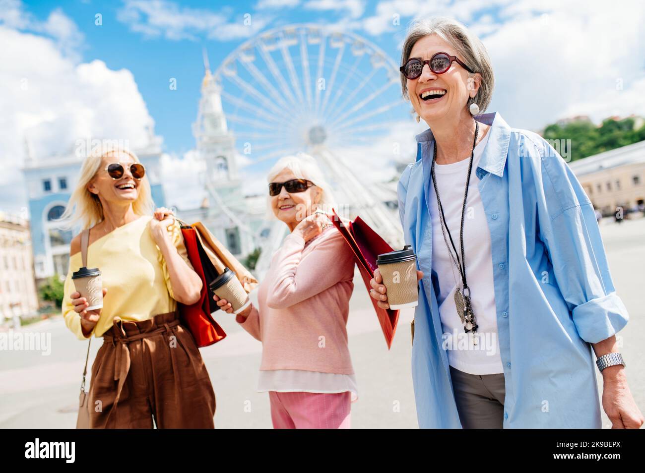 Beautiful happy senior women meeting outdoors and shopping in the city ...