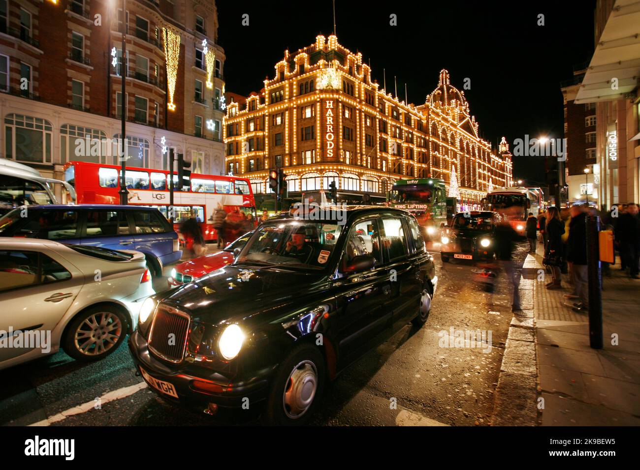 London, UK - December 8, 2012: Night View of Harrods, taxi present ...
