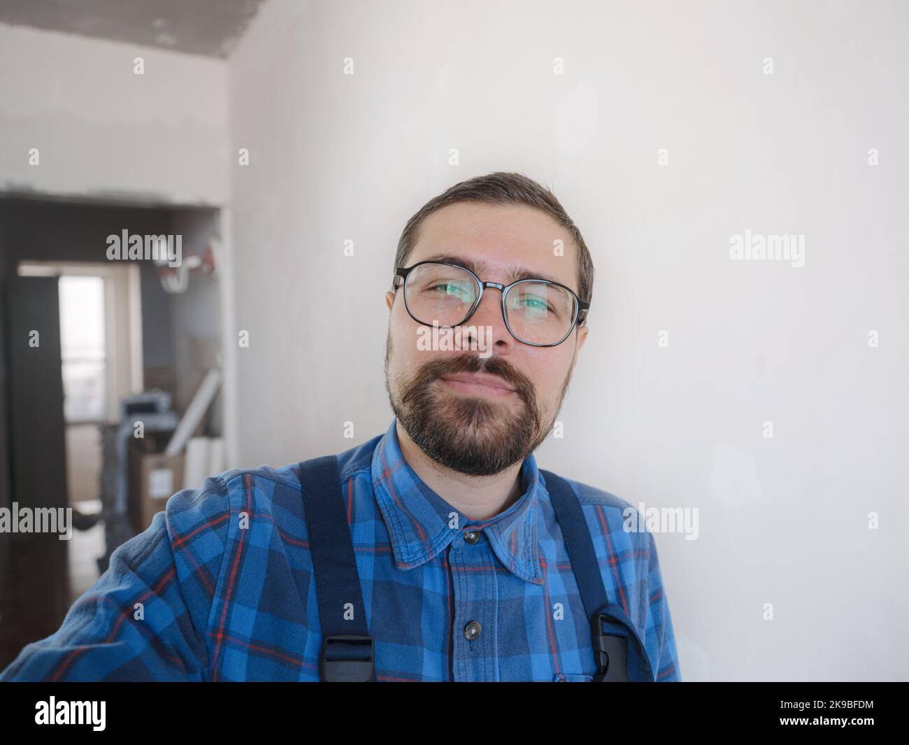 young man in blue work suit doing Repair apartment. Home renovation ...