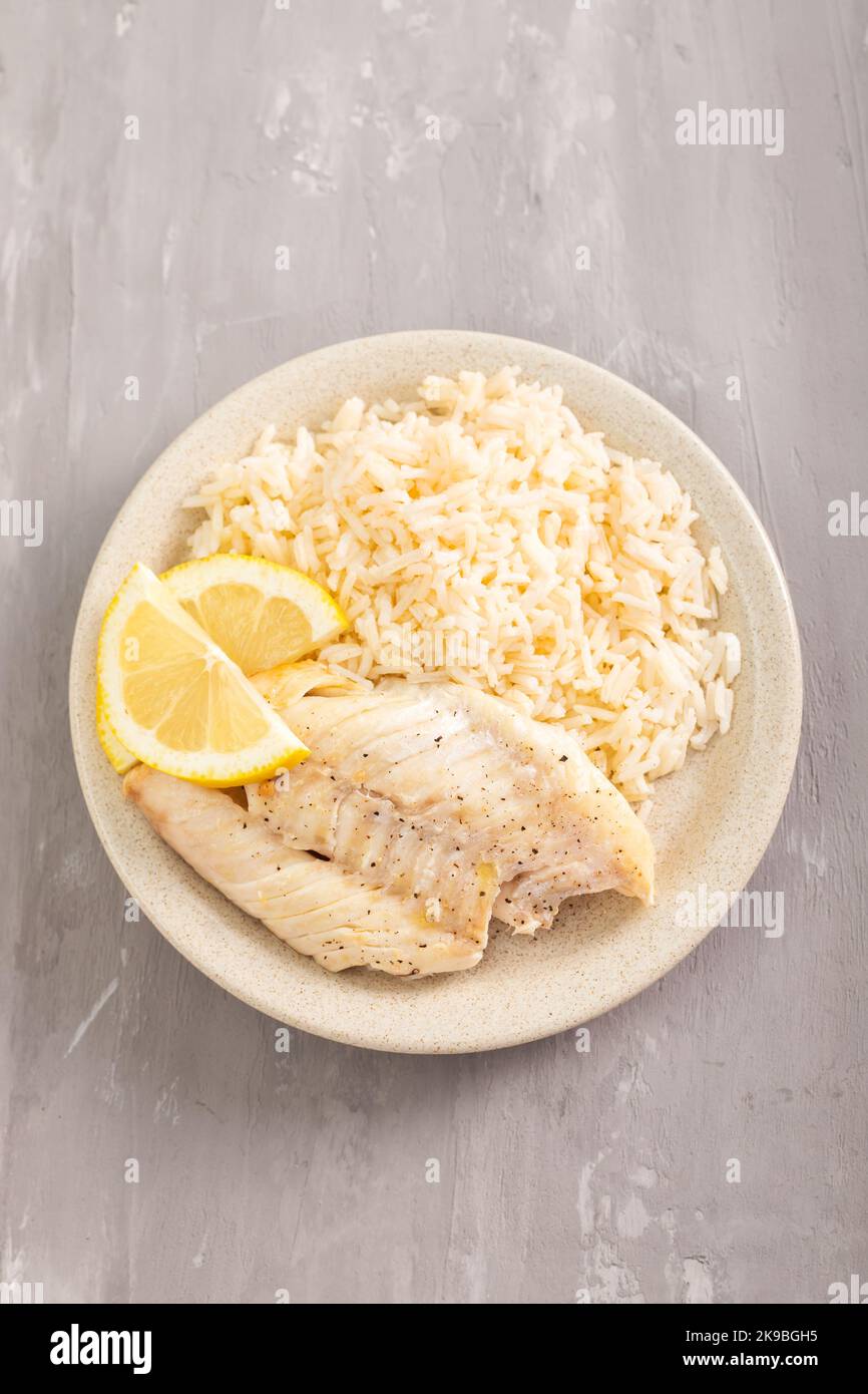 Fried fish fillet with boiled white rice on white dish Stock Photo - Alamy