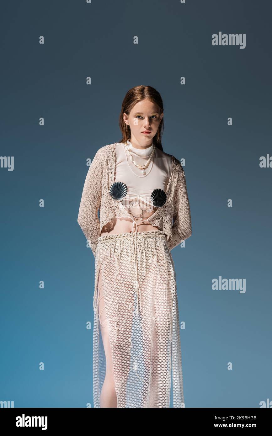Young model in fishnet skirt standing on gradient blue background Stock ...