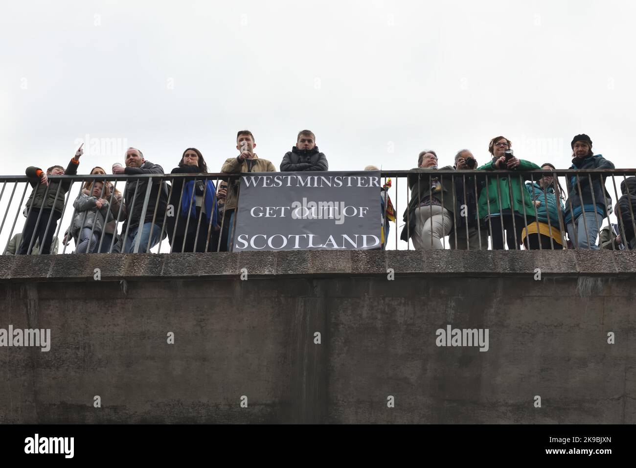 A group of activists on an overhead walkway with a sign stating a ...