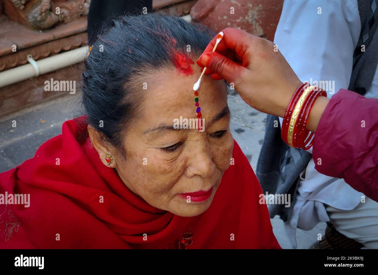 Kathmandu, Bagmati, Nepal. 27th Oct, 2022. A woman recieves colorful ...