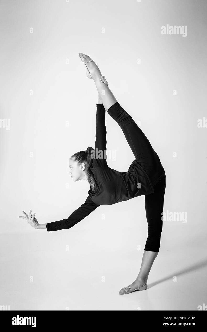 the silhouette of a rhythmic gymnastics girl in a bodysuit shows an ...