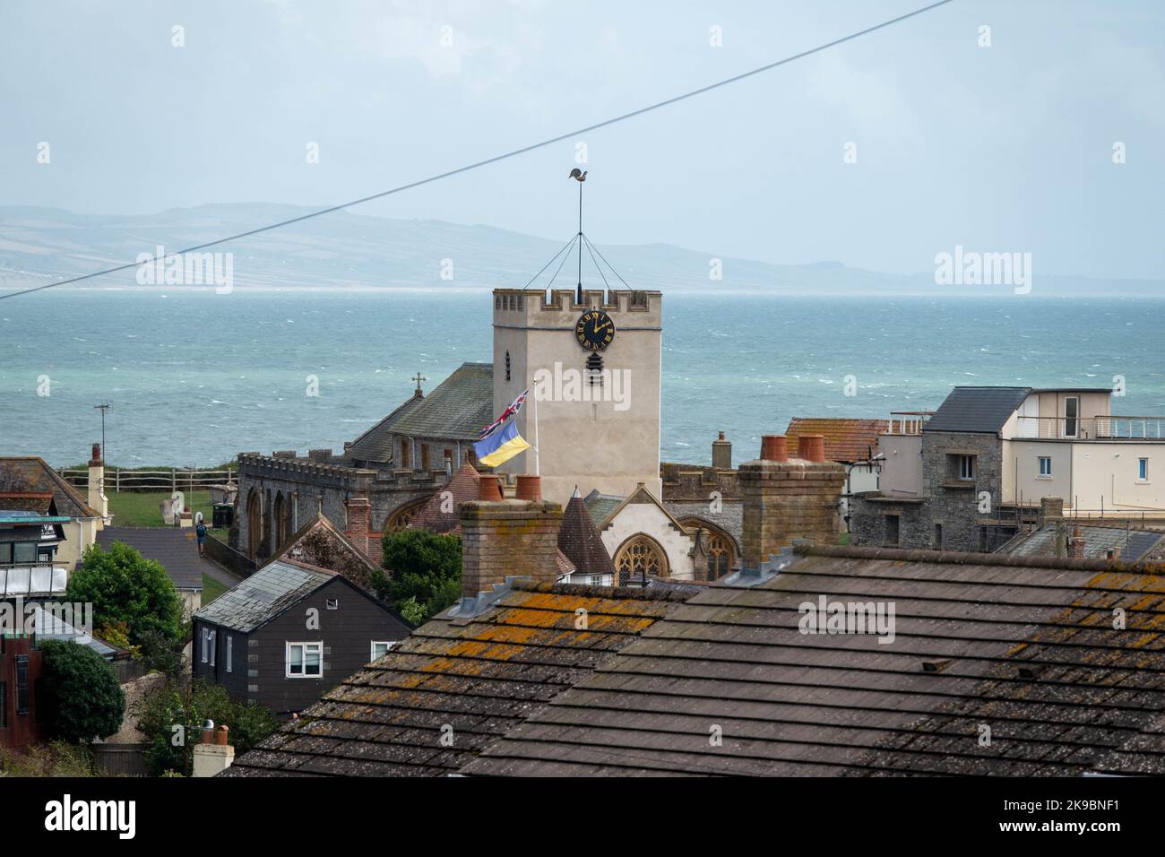 view of St Michaels Church and the sea at Lyme Regis across roof tops ...