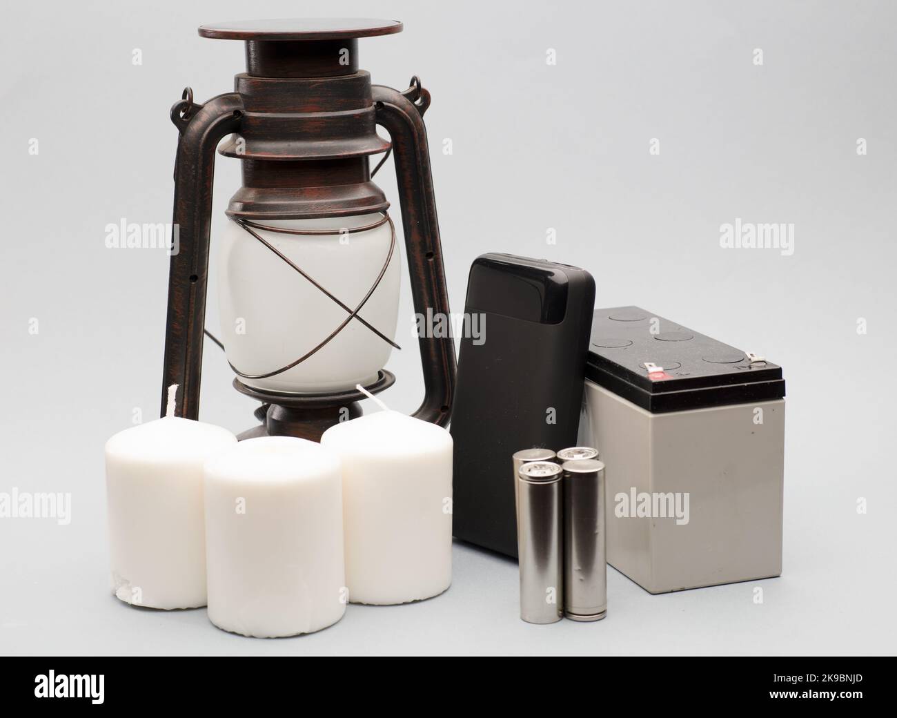 oil lamp, power bank with batteries, white candles and battery with connection bolts gray ...