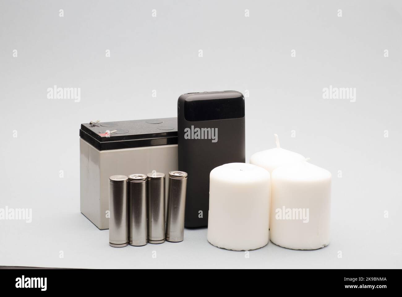 emergency power equipment, power bank with batteries, white candles and ...