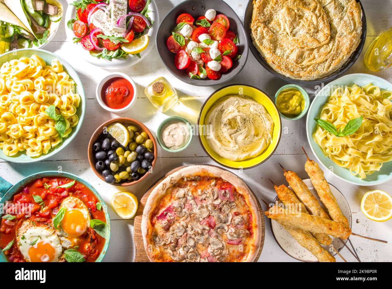 Set of different Mediterranean foods: olives, mozzarella tomato salad ...