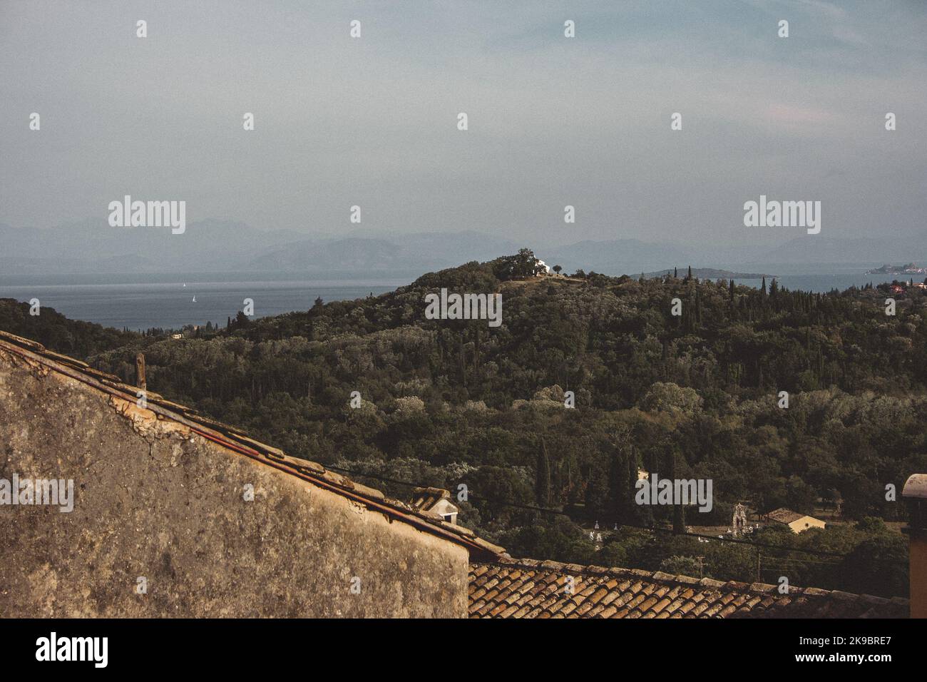 Corfu, Greece. view of a mountain with green trees and a white house ...
