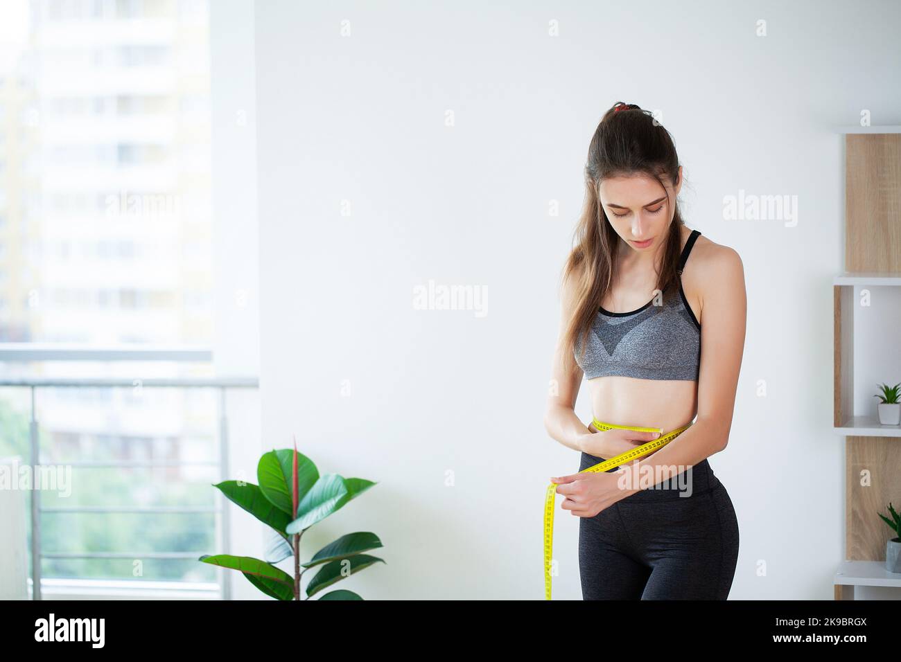 Slim young woman measuring her thin waist with a tape measure Stock ...