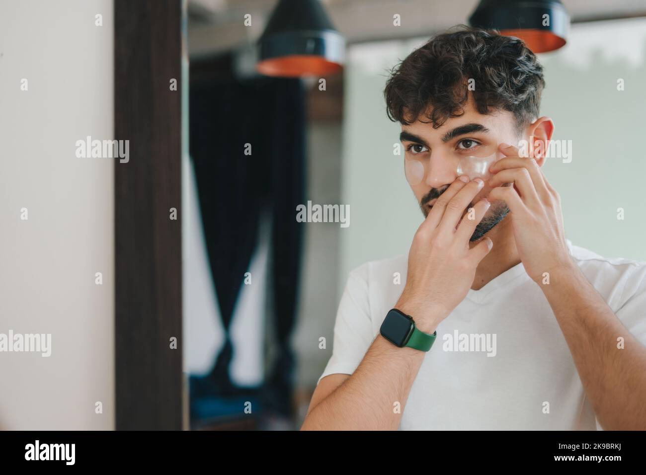 Portrait of handsome man touching his cheek with rubbing moisturizing ...