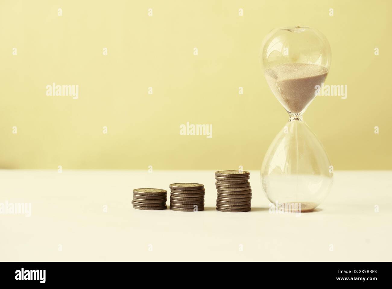 Clock on stack coins hi-res stock photography and images - Alamy