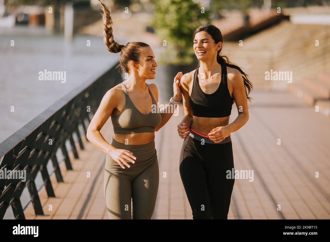 Pretty young woman taking running exercise by the river promenade Stock ...