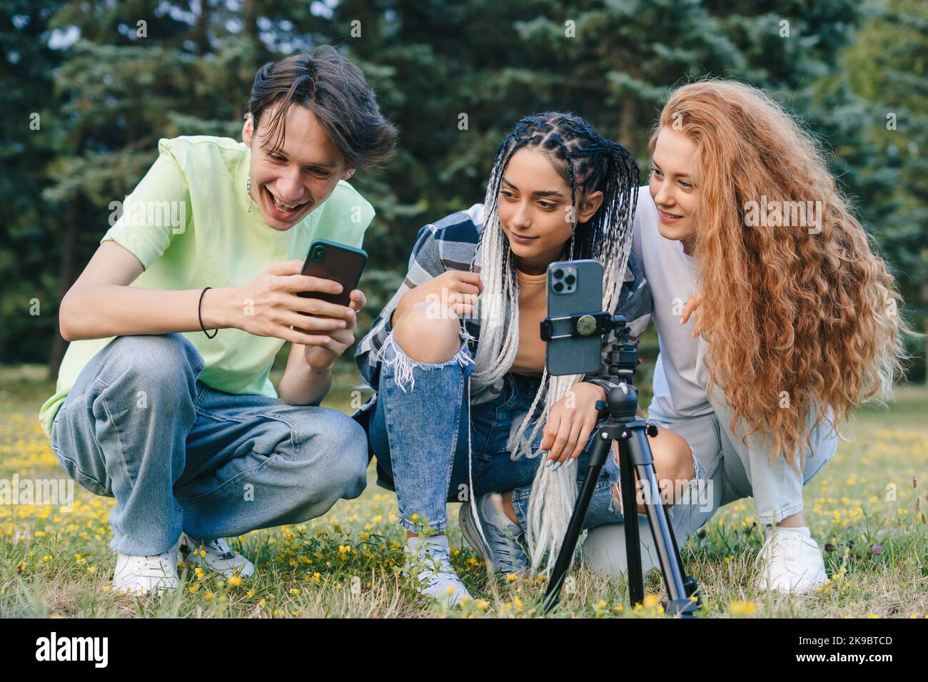 Generation Z friends standing in the park watching viral videos on the ...