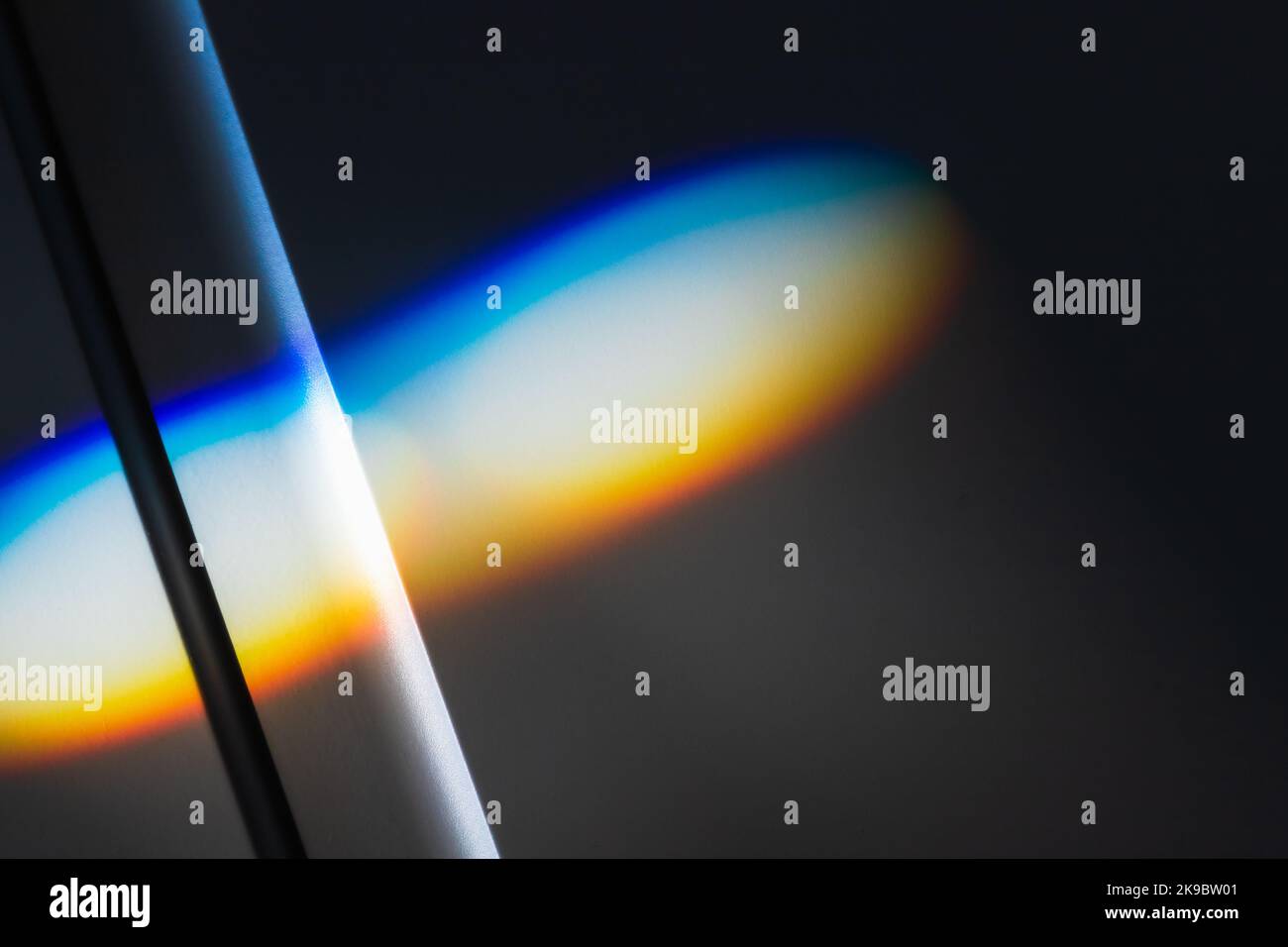 Sunbeam with spectrum colors lays over white wall, refraction effect ...