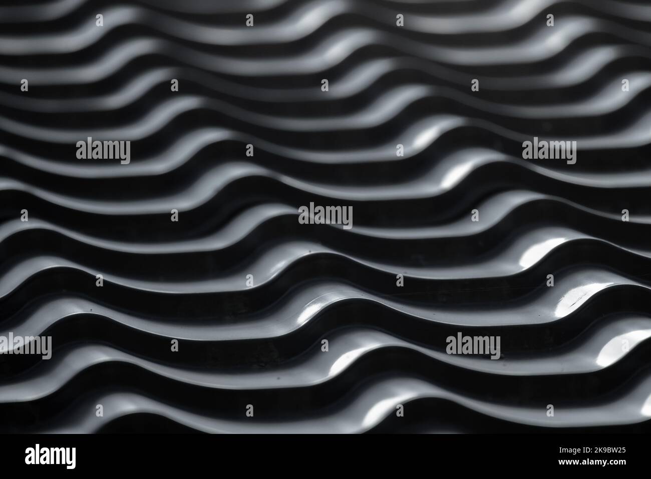 Gray metal roof tiling with wavy shape pattern, close up black and ...