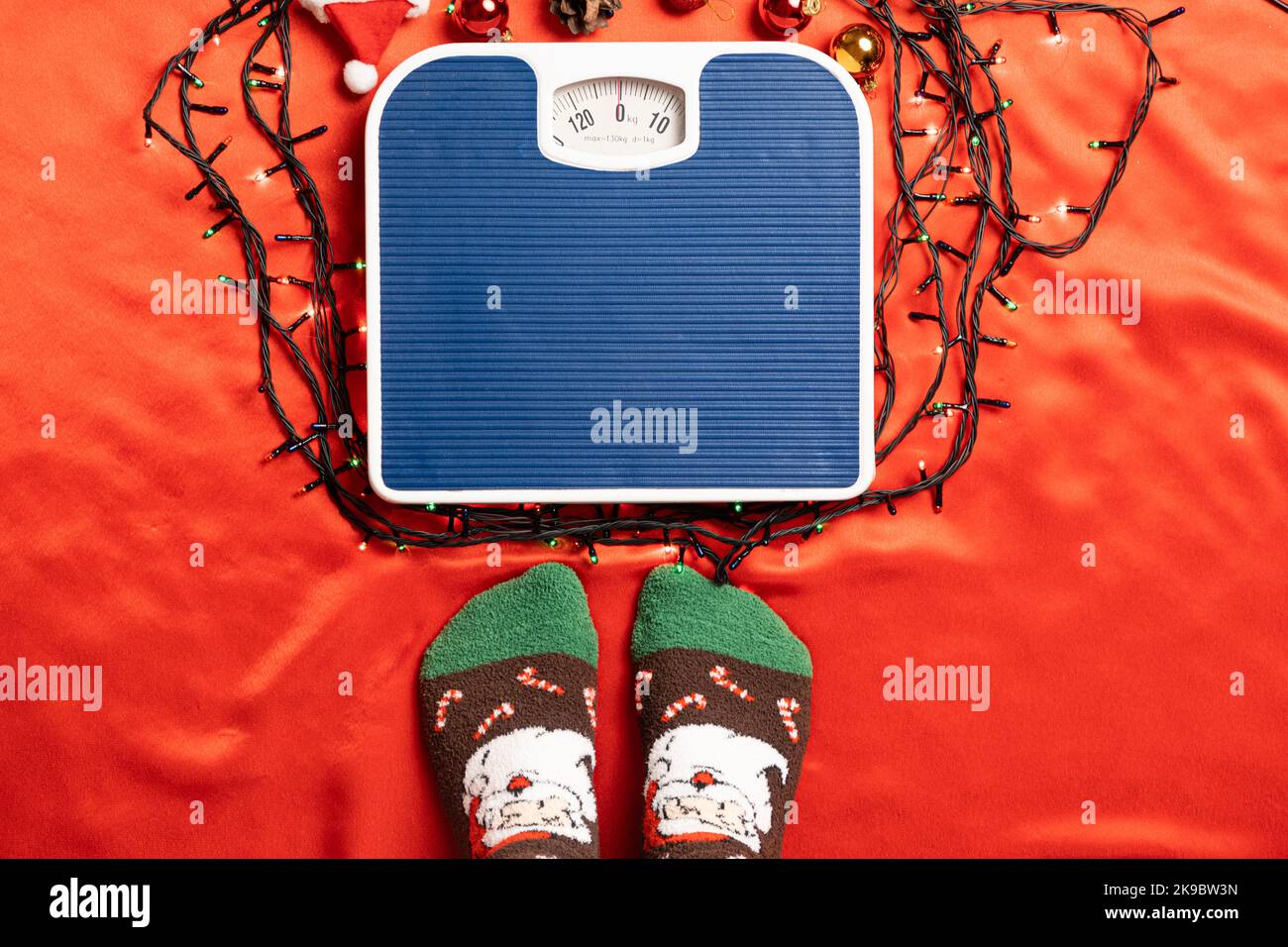 A woman is going to stand on the scales on a red background, weight ...