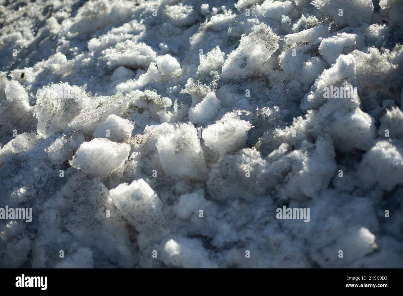 Snow outside in spring. Cleared snow on side of road. Breaking ice ...
