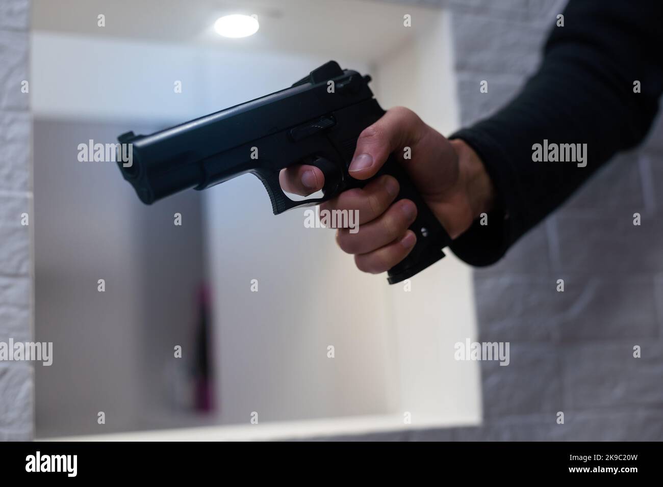 Threat of firearms. Muzzle of gun in man's hand is pointed at camera ...