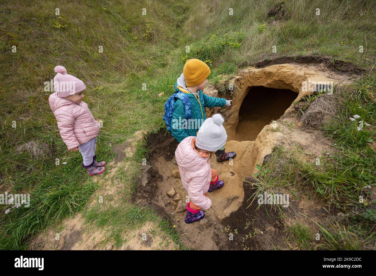 Three kids explore limestone stone cave at mountain Stock Photo - Alamy