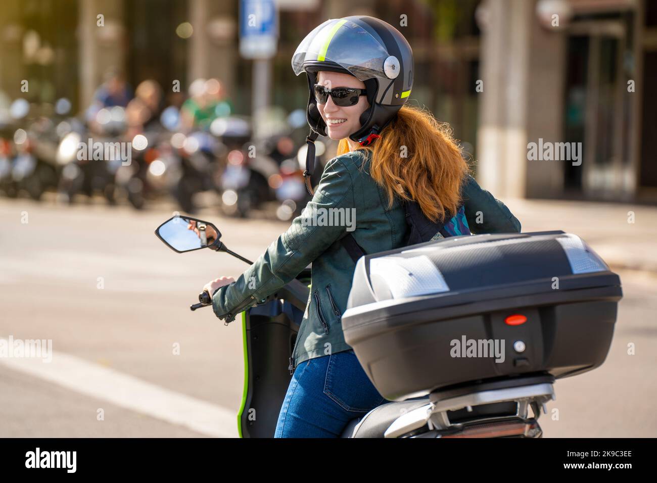 Red-haired woman riding a motorcycle on a city street Stock Photo - Alamy