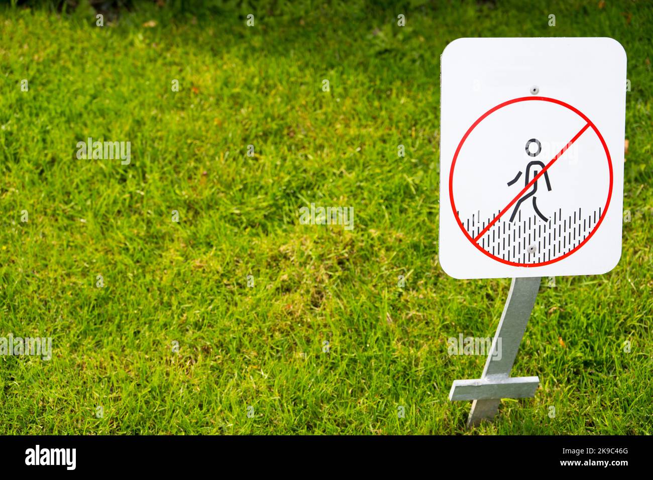 Close up of metal sign with red crossed out figure placed on lawn in ...