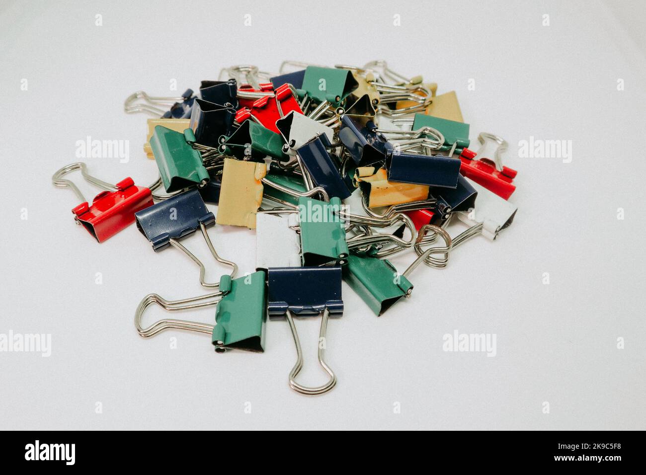 colored paper clips on a white background Stock Photo - Alamy