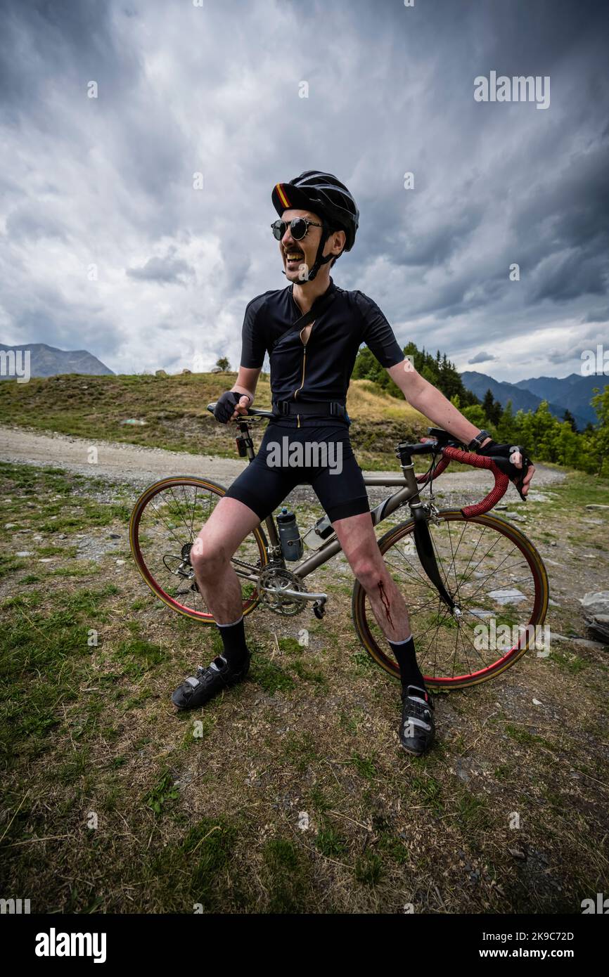 Male cyclist taking a rest from gravel cycling and assessing his ...