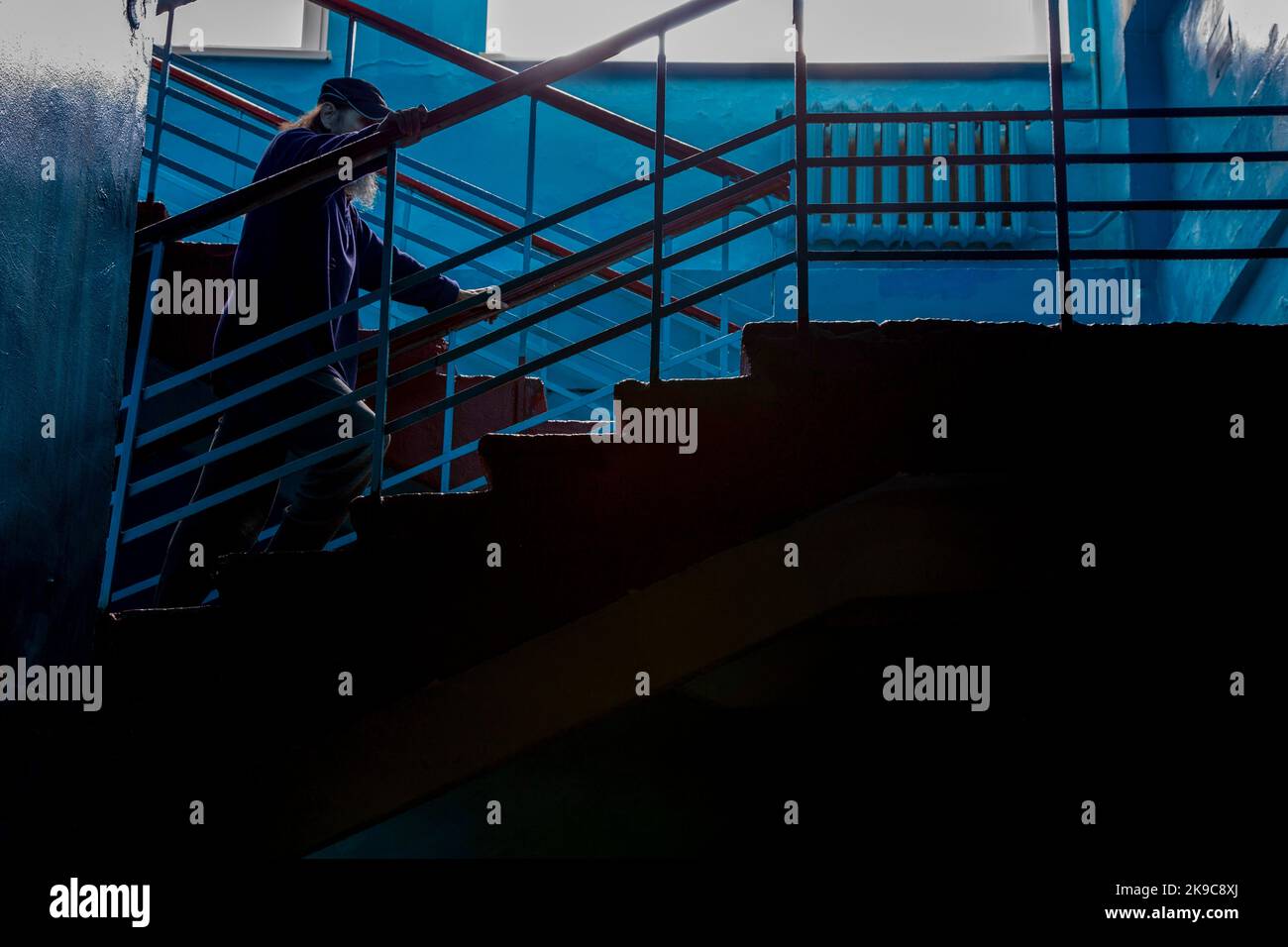 A man climbs the stairs inside a residential building Stock Photo - Alamy